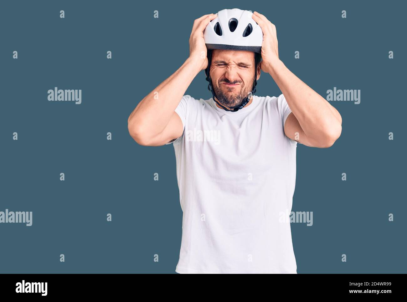 Young handsome man wearing bike helmet suffering from headache ...