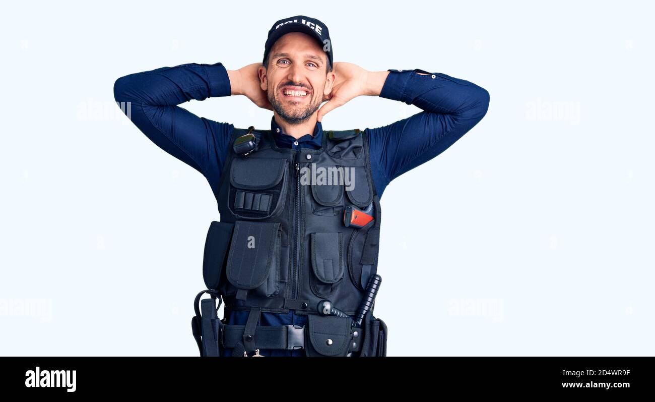 Young handsome man wearing police uniform relaxing and stretching, arms ...