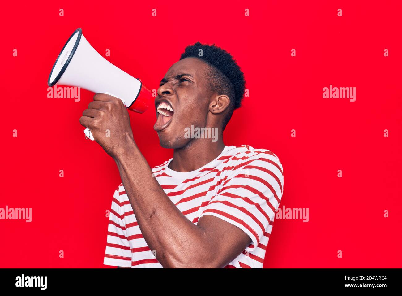 Young african man shouting angry throught megaphone Stock Photo - Alamy
