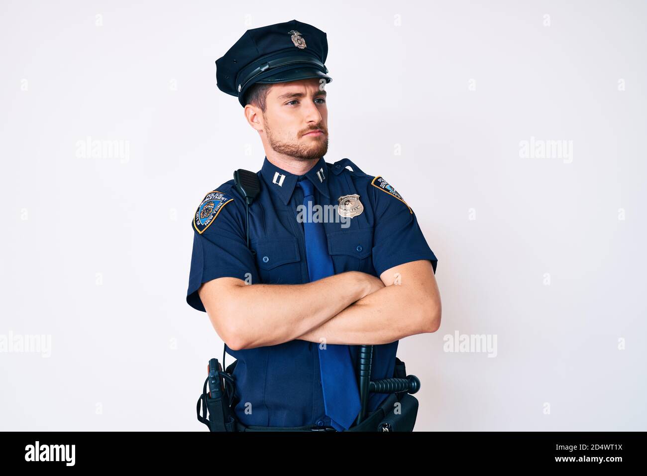 Young caucasian man wearing police uniform looking to the side with ...
