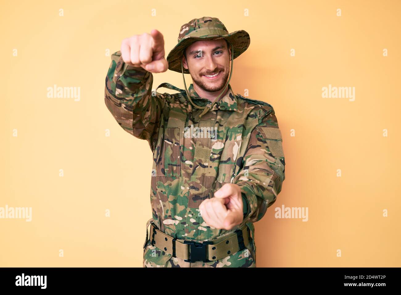 Young caucasian man wearing camouflage army uniform pointing to you and ...