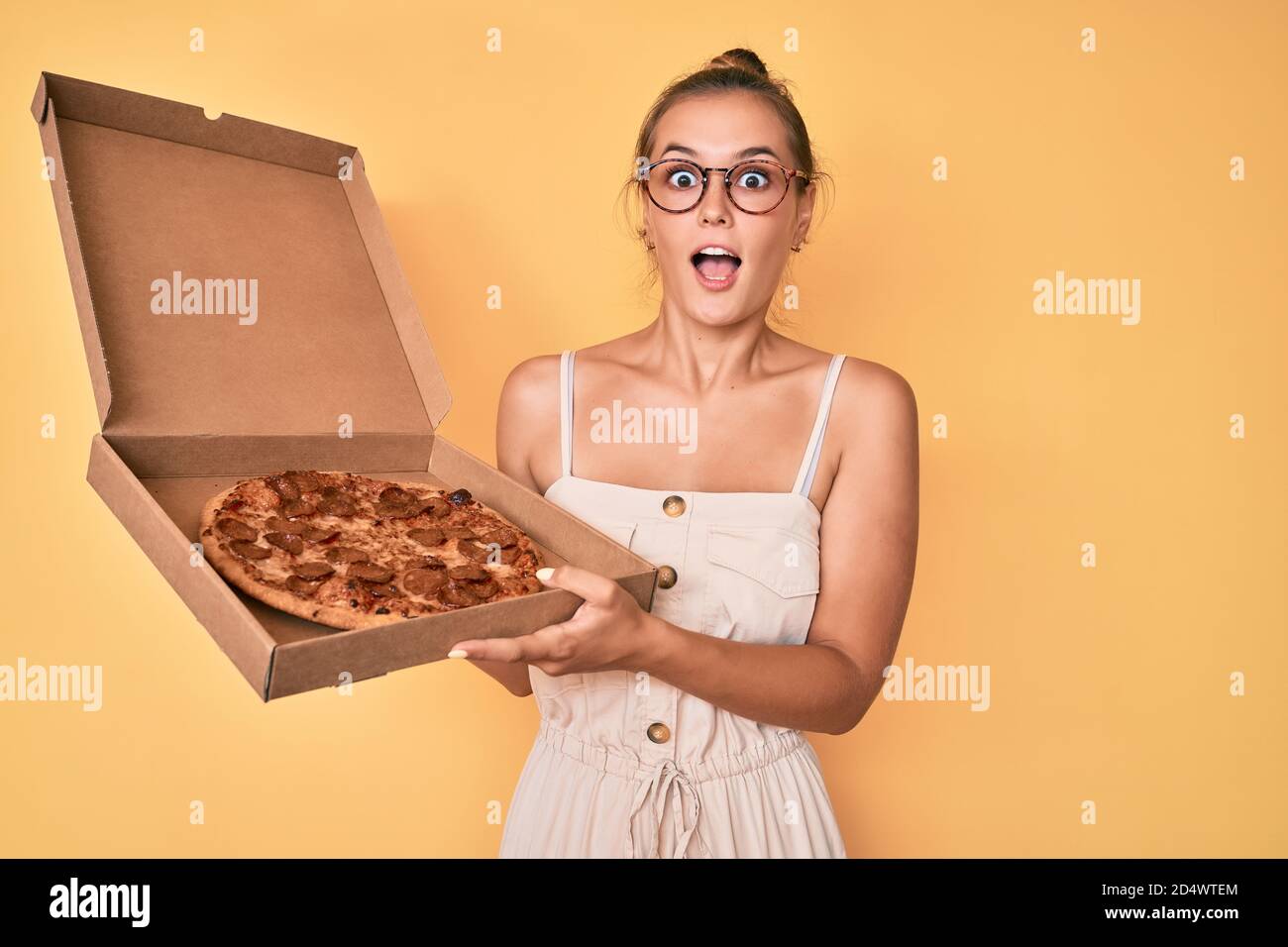 Beautiful caucasian woman holding tasty pepperoni pizza celebrating ...