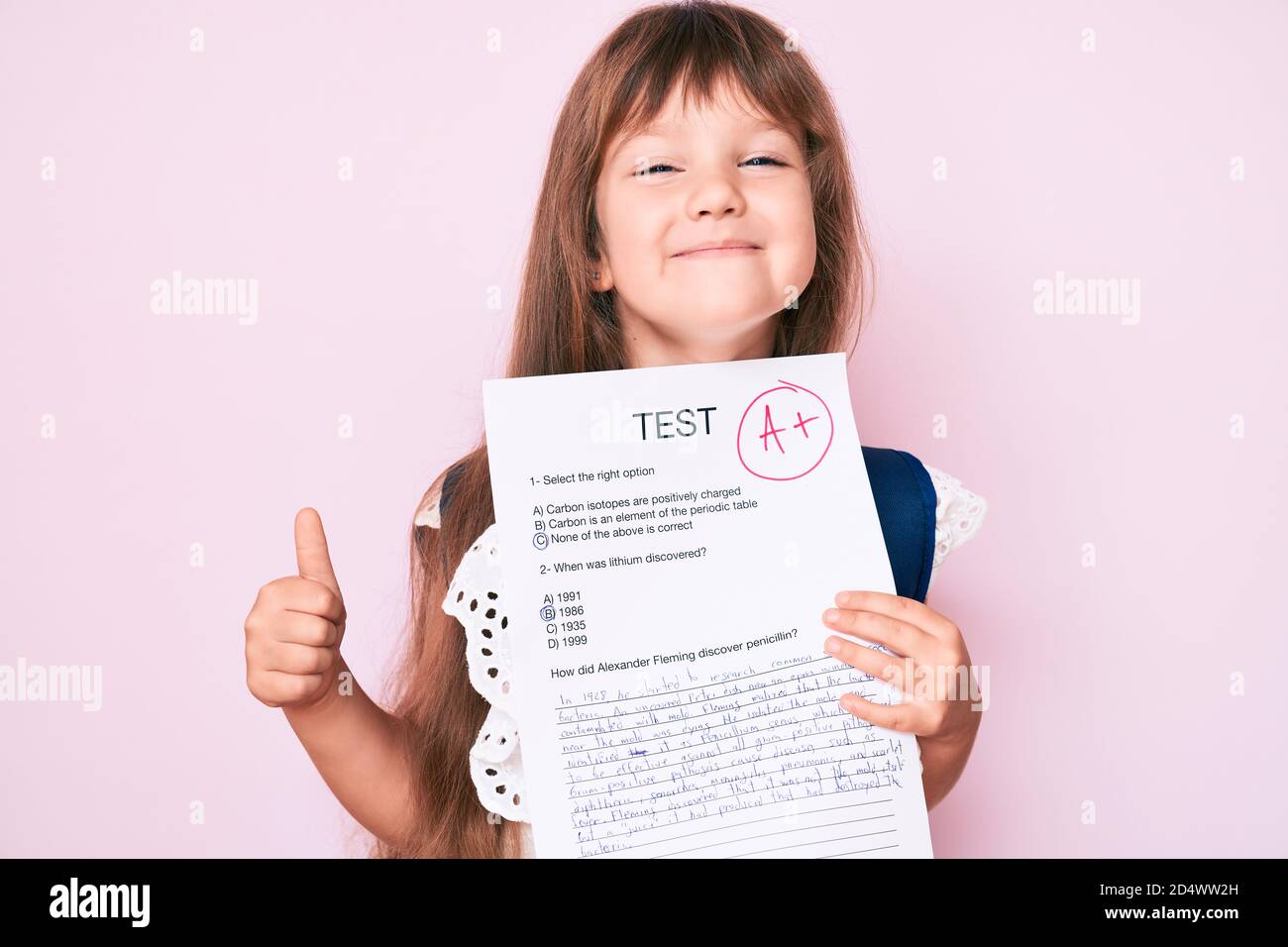 Little caucasian kid girl with long hair showing a passed exam from ...