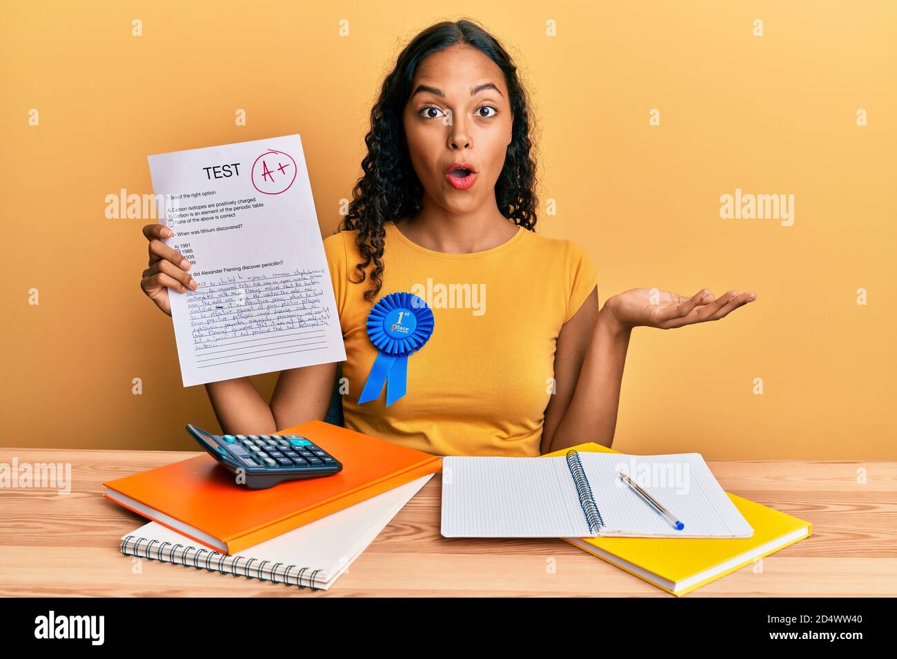 Young african american girl showing a passed exam scared and amazed ...