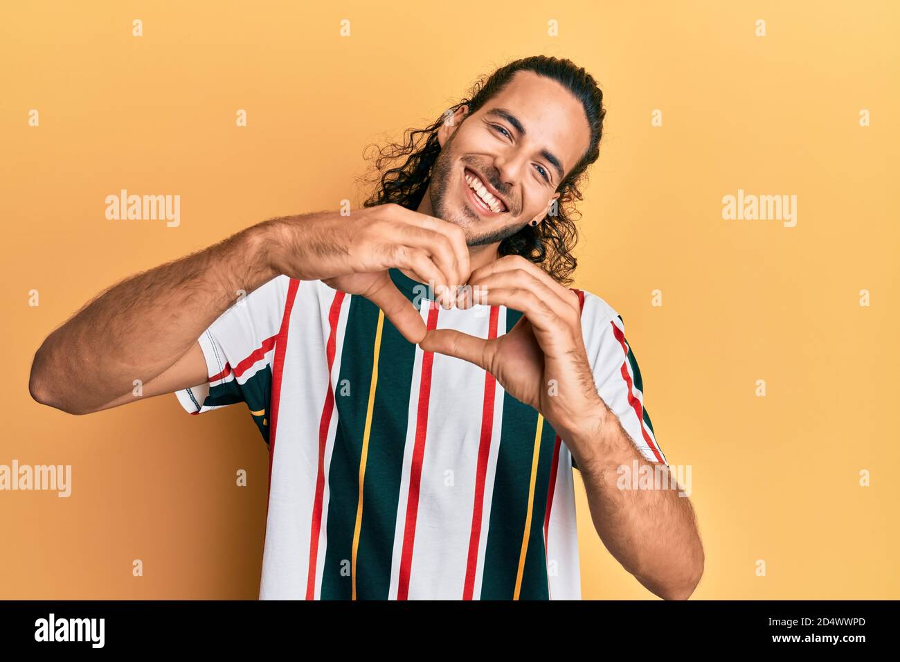 Young handsome man with long hair wearing casual clothes smiling in ...
