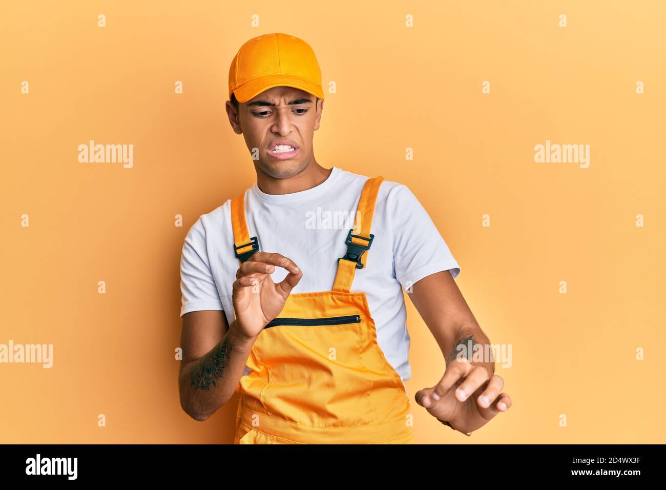 Young handsome african american man wearing handyman uniform over ...