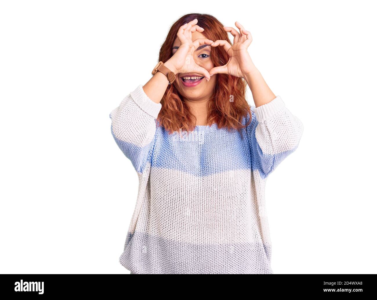 Young latin woman wearing casual clothes doing heart shape with hand ...