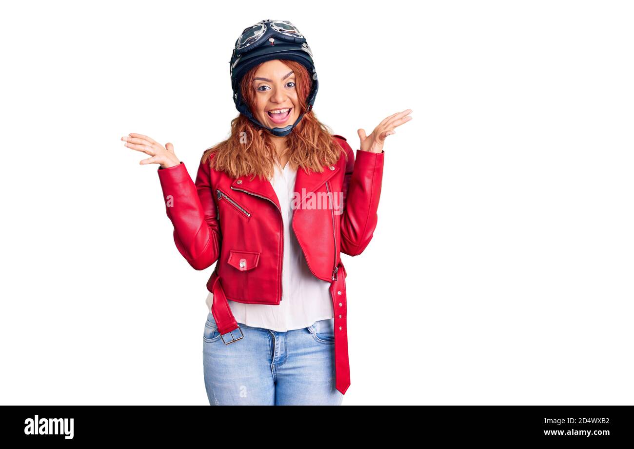 Young latin woman wearing leather jacket holding motorcycle helmet ...