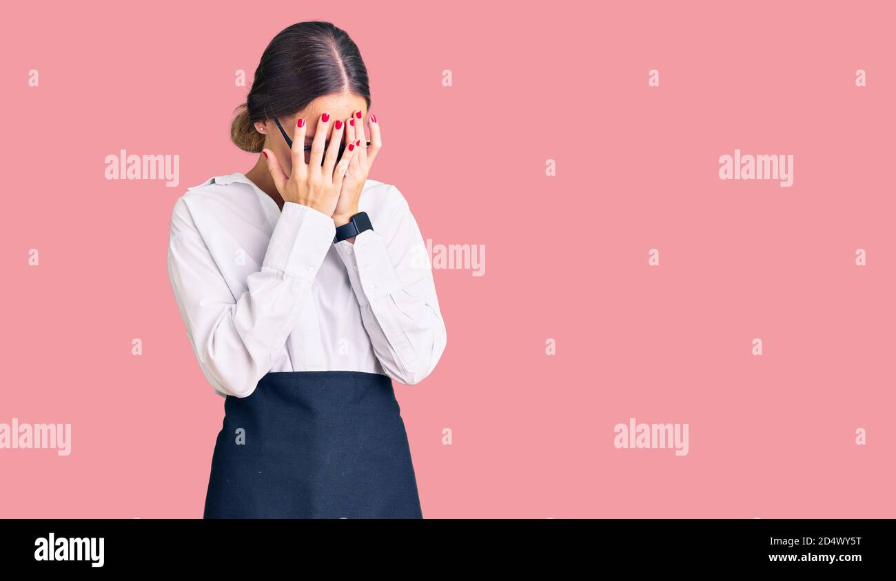 Beautiful brunette young woman wearing professional waitress apron with ...