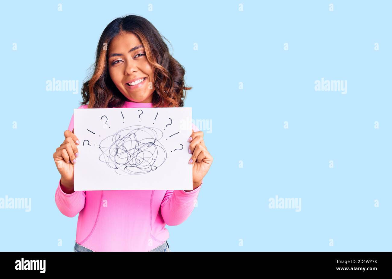 Young beautiful mixed race woman holding scribble draw looking positive ...