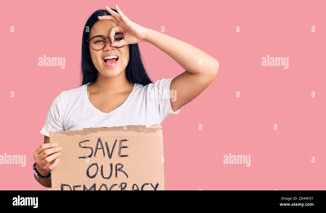 Young beautiful asian girl holding save our democracy protest banner ...