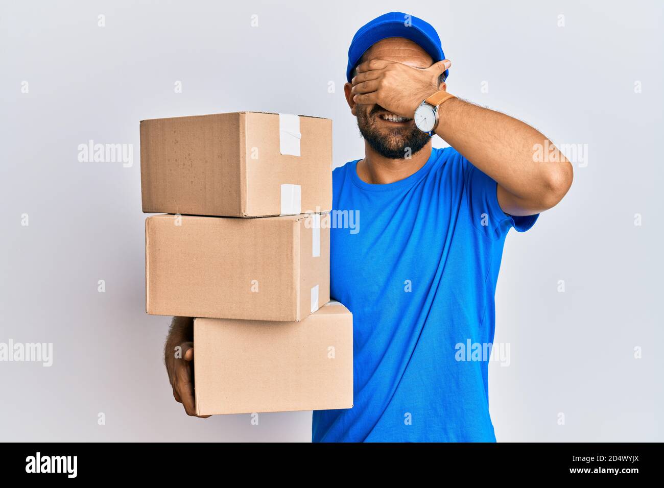 Handsome man with beard wearing courier uniform holding delivery ...