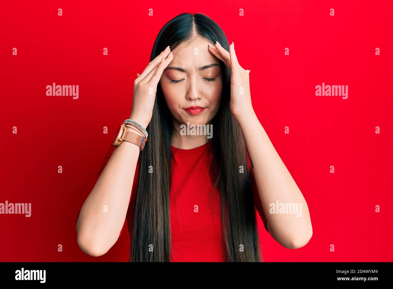Young chinese woman wearing casual clothes with hand on head, headache ...