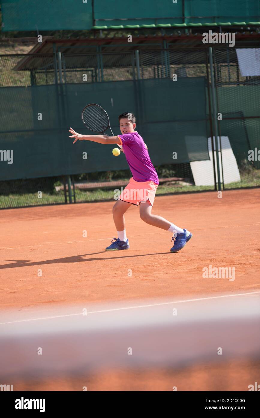 Young tennis player hitting the ball Stock Photo - Alamy