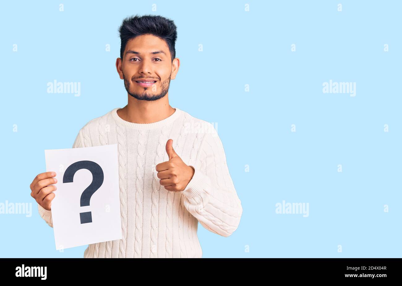 Handsome latin american young man holding question mark smiling happy ...