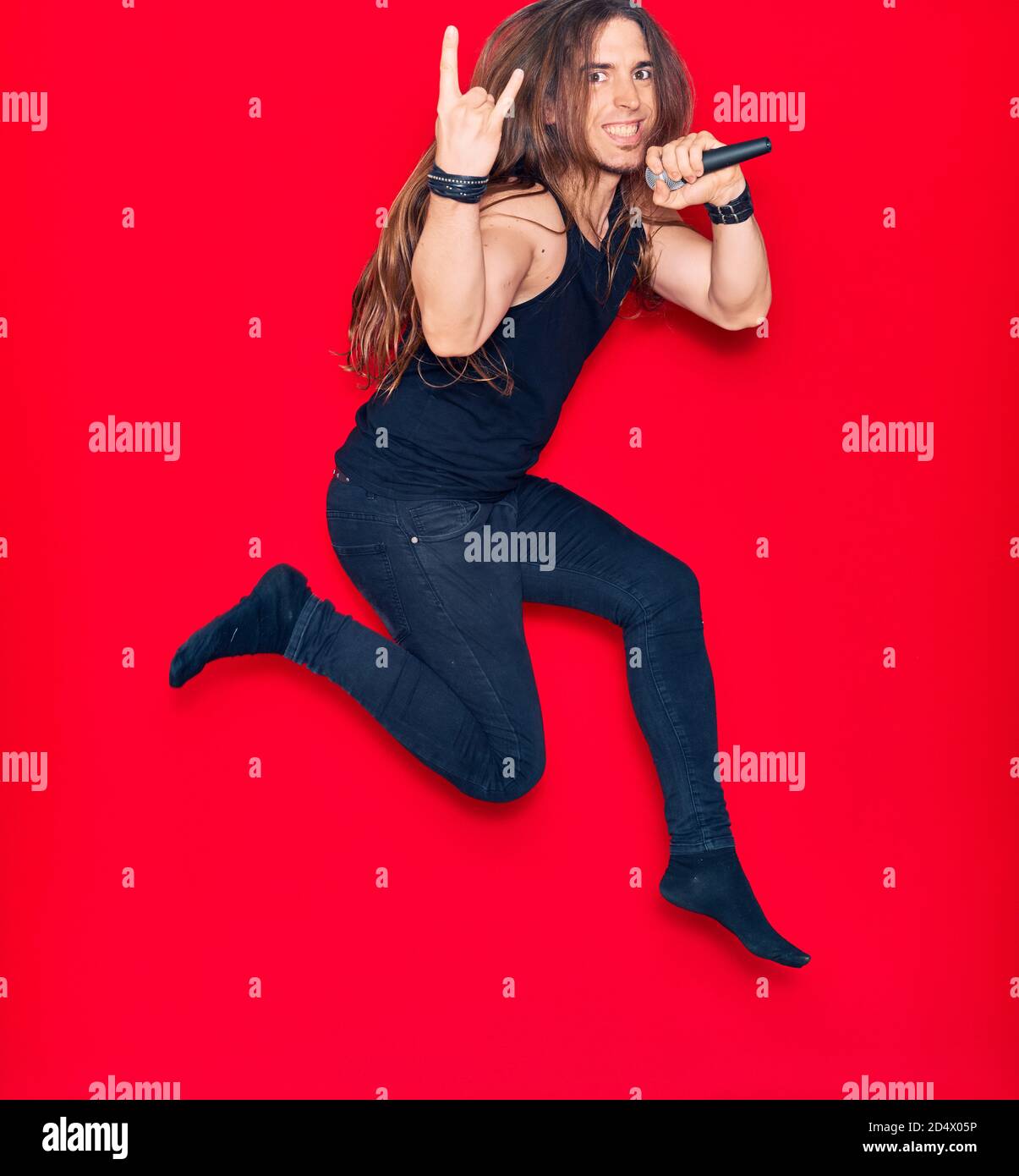 Young handsome heavy metal singer man with long hair and aggressive ...