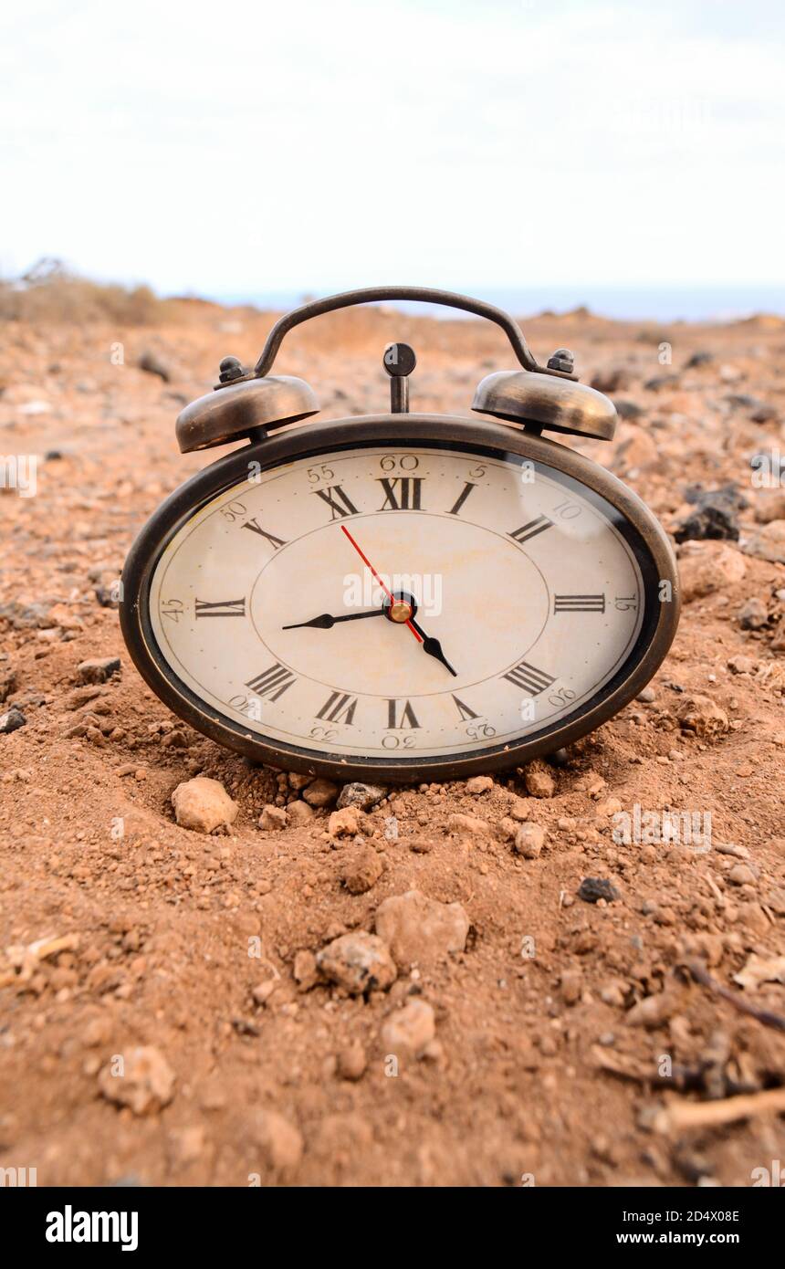 Classic Analog Clock In The Sand Stock Photo - Alamy