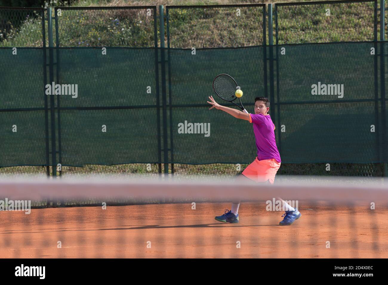 Young tennis player hitting the ball Stock Photo - Alamy
