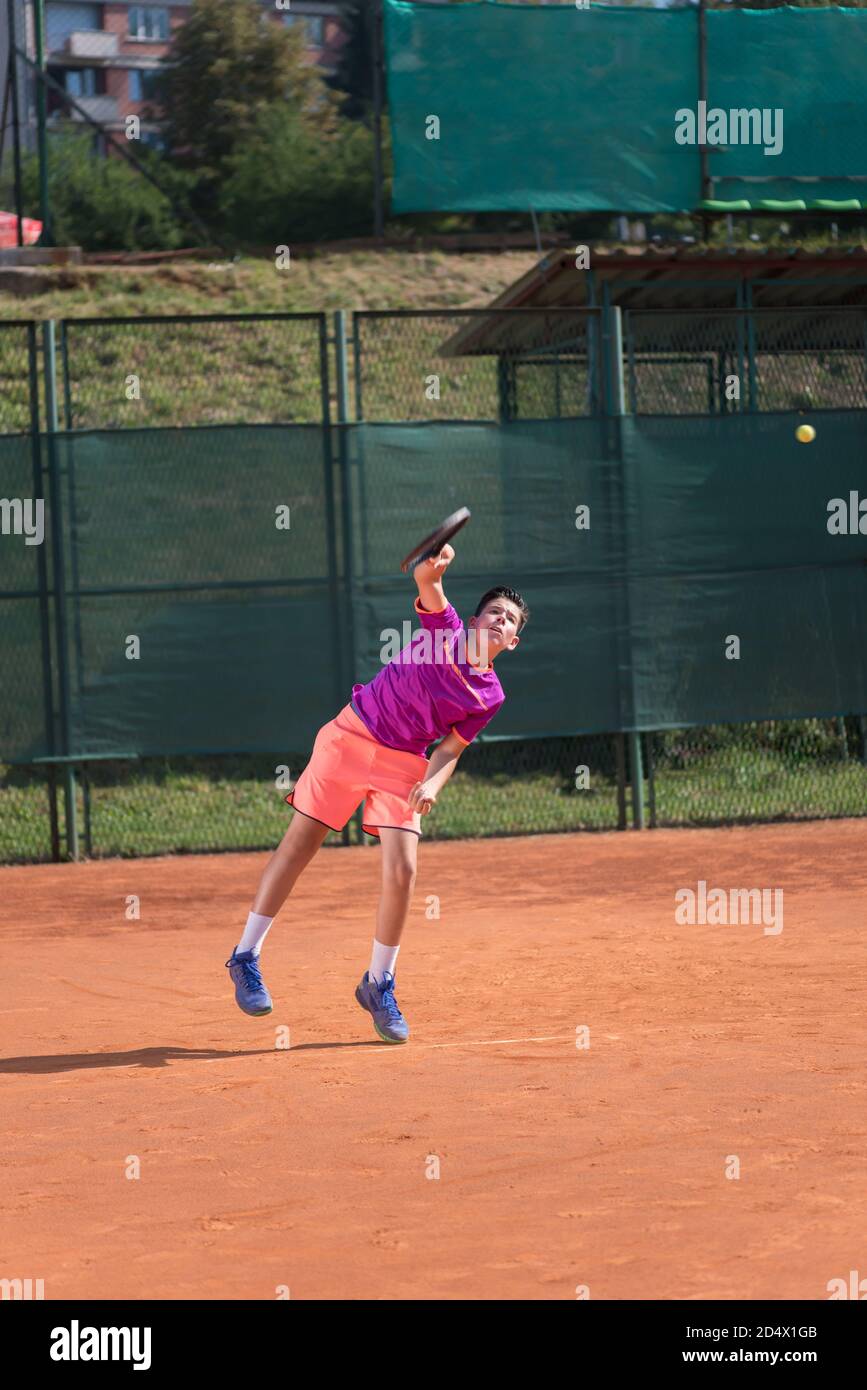 Young tennis player serving the ball Stock Photo - Alamy