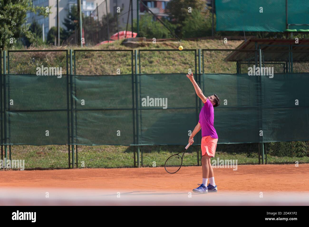 Young tennis player serving the ball Stock Photo - Alamy
