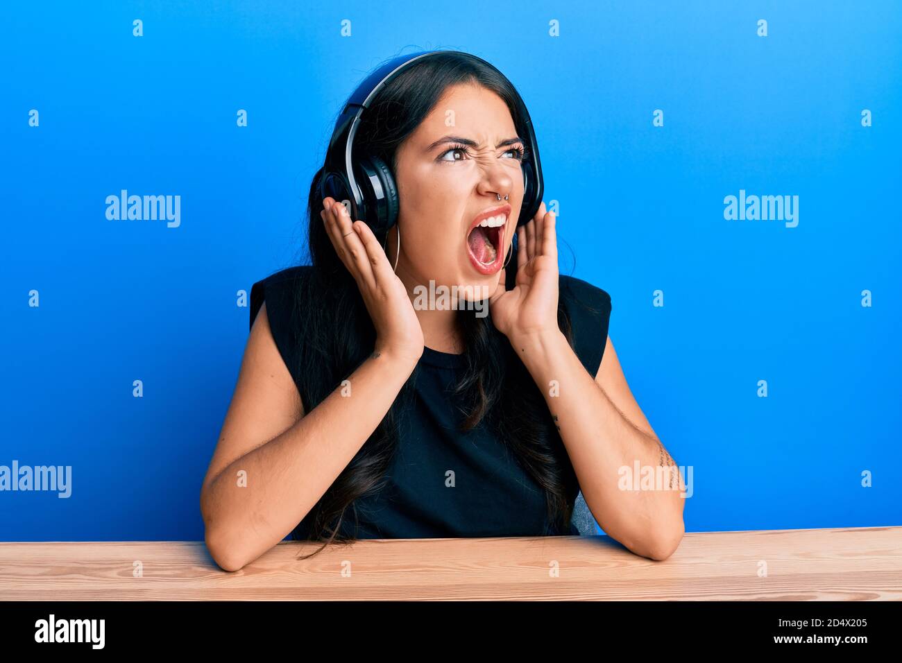 Beautiful brunette young woman listening to music using headphones ...