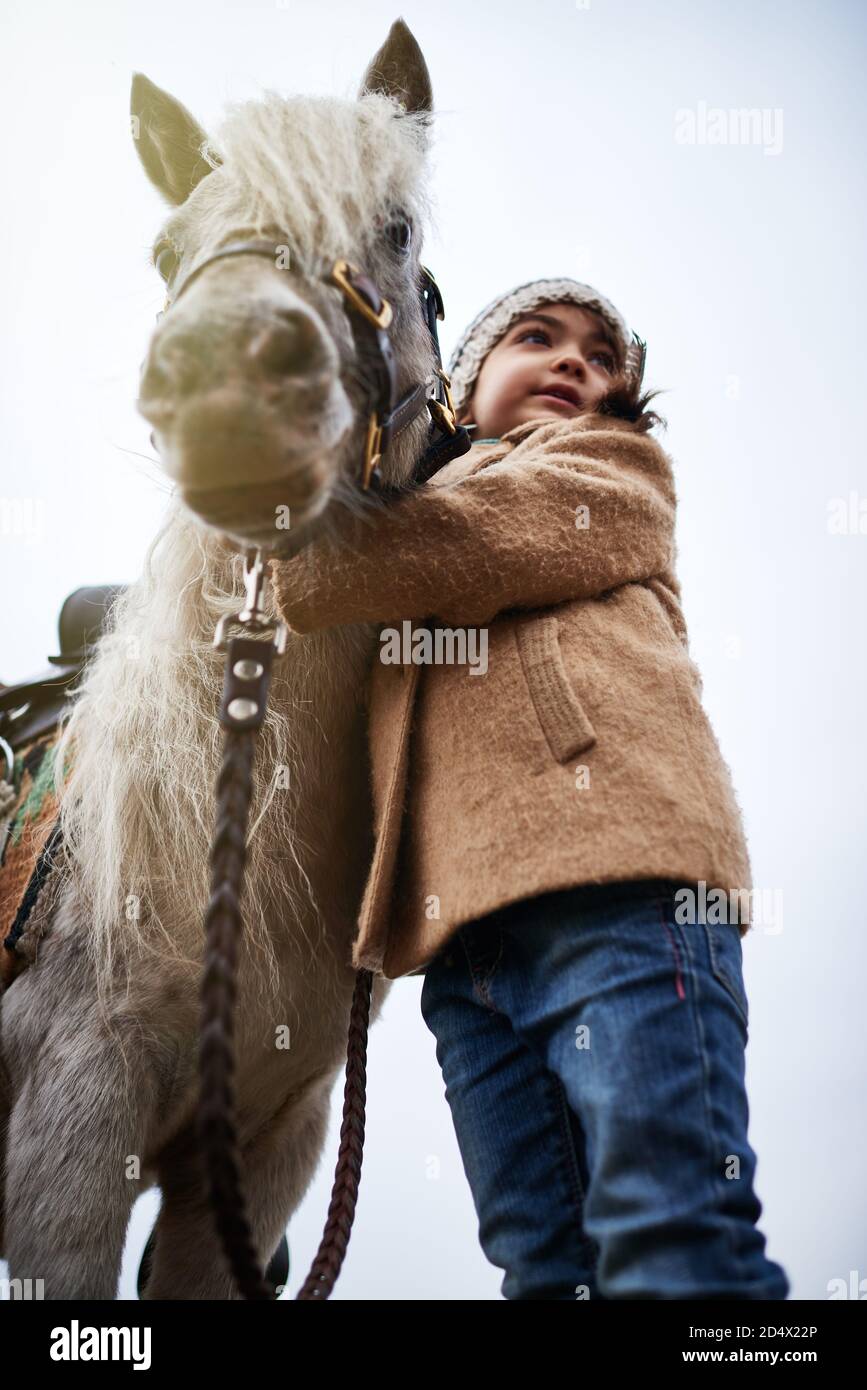 Happy Little Girl Hugging Pony Stock Photo - Alamy