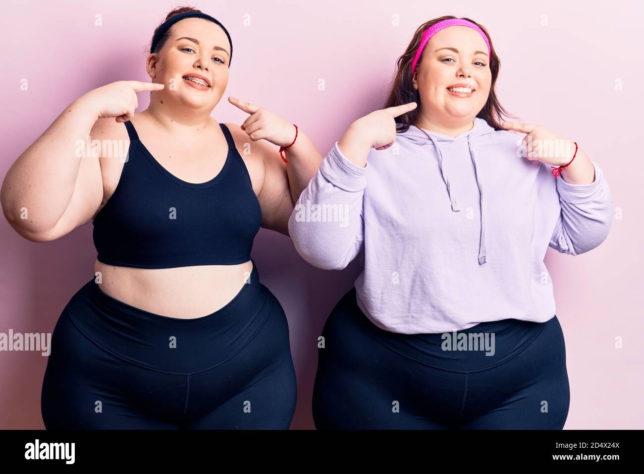 Young plus size twins wearing sportswear smiling cheerful showing and ...