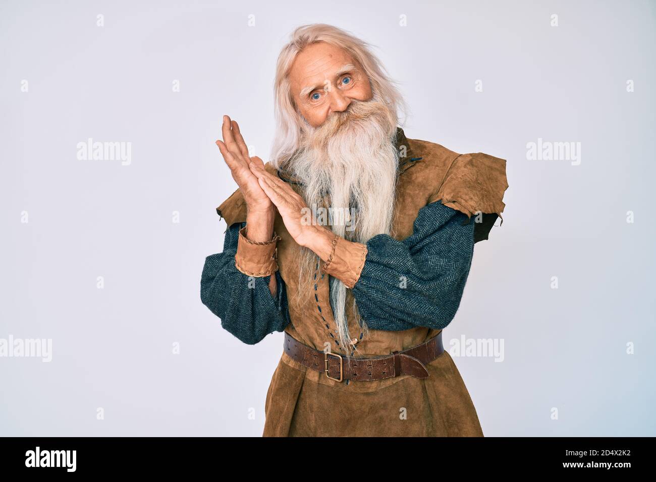 Old senior man with grey hair and long beard wearing viking traditional ...