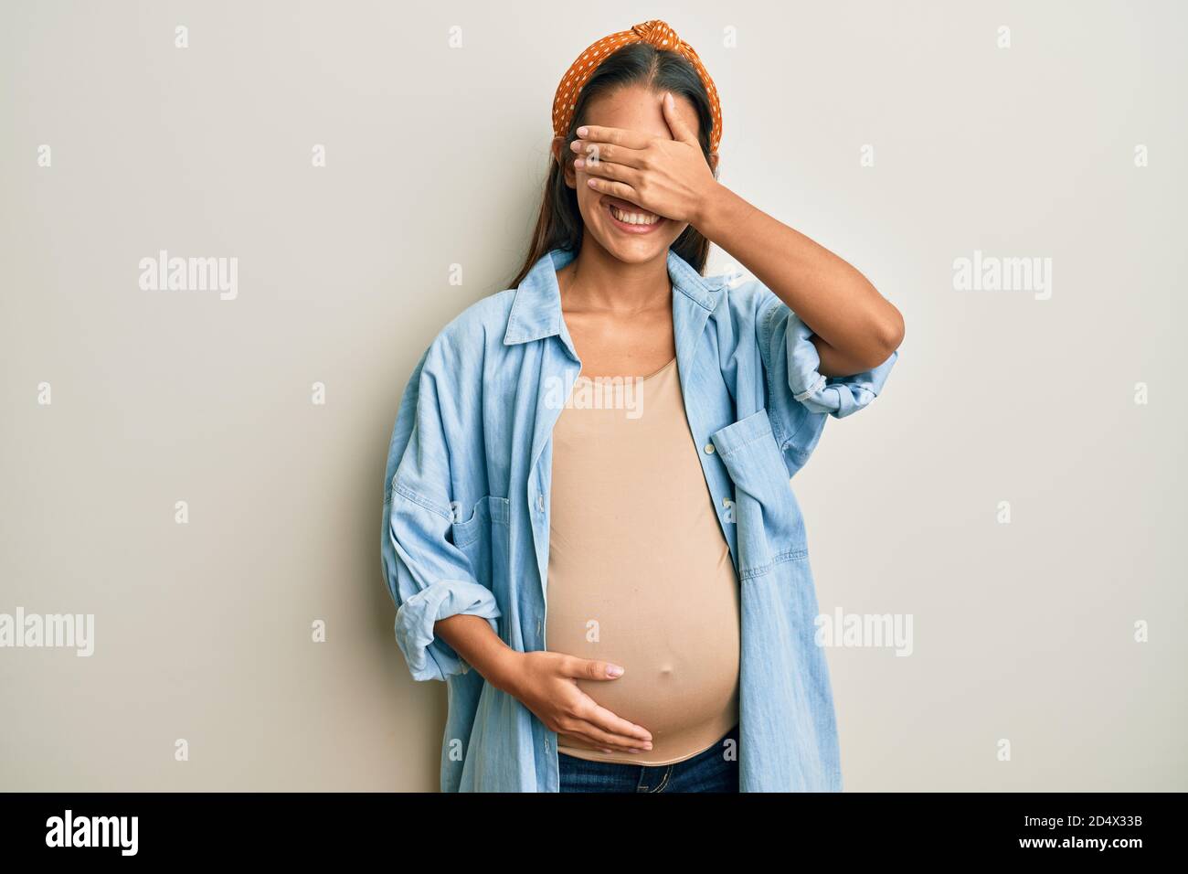 Beautiful hispanic woman expecting a baby, touching pregnant belly ...