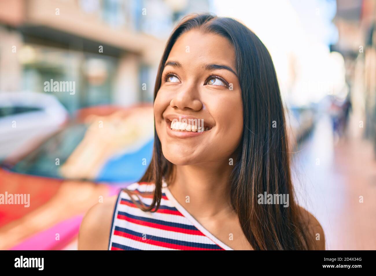 Young latin girl smiling happy walking at the city Stock Photo - Alamy