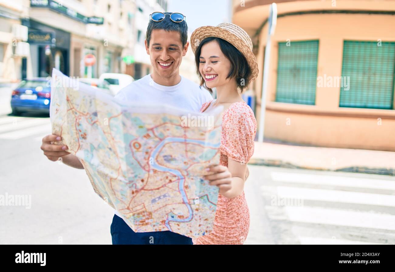 Beautiful couple on vacation smiling happy holding city map at street ...