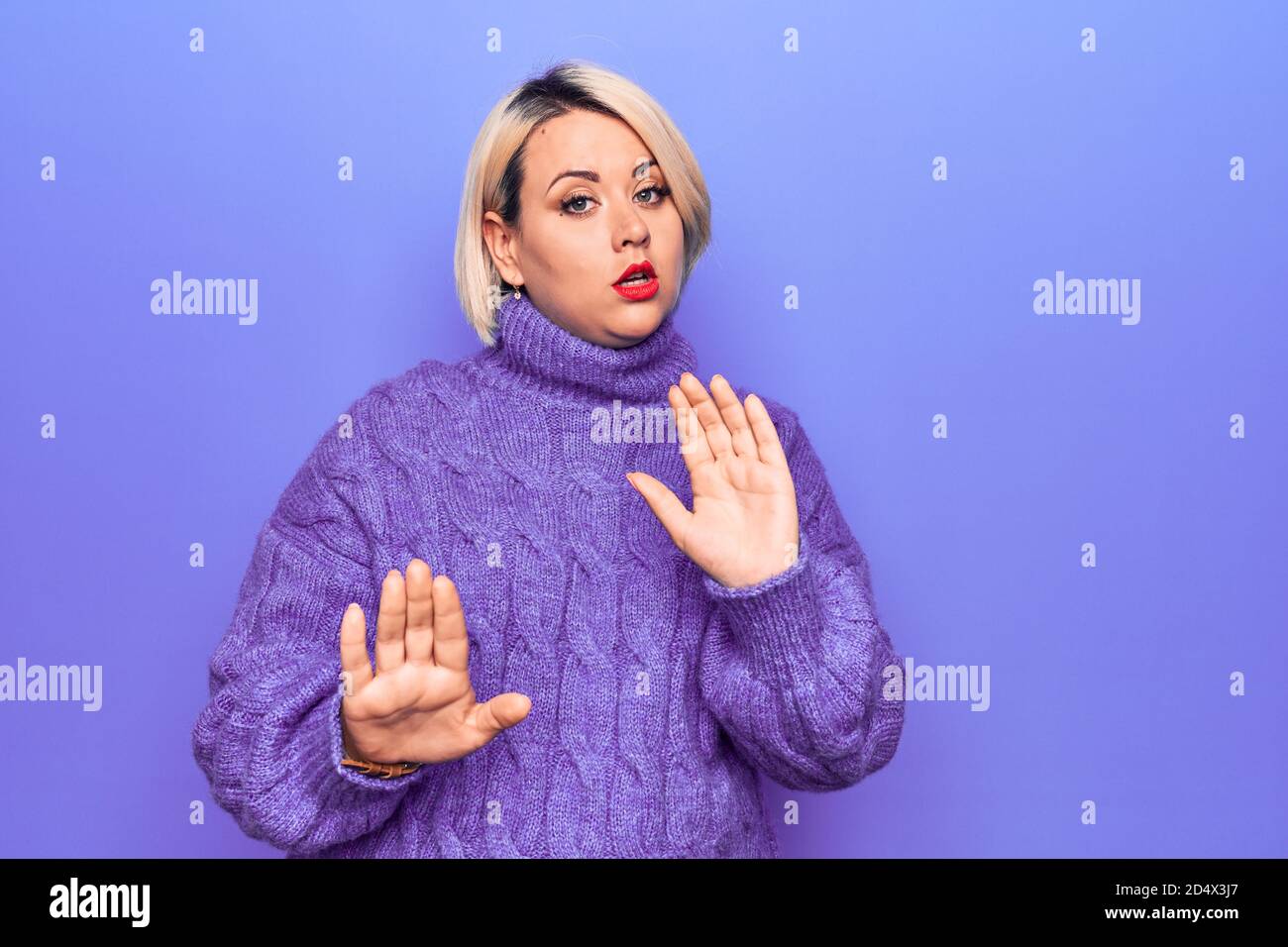 Beautiful blonde plus size woman wearing casual turtleneck sweater over ...