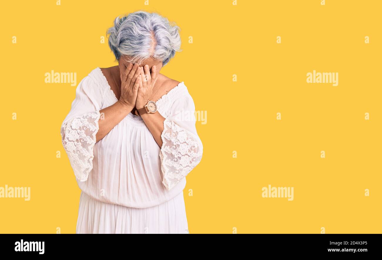 Senior woman with gray hair wearing bohemian style with sad expression ...
