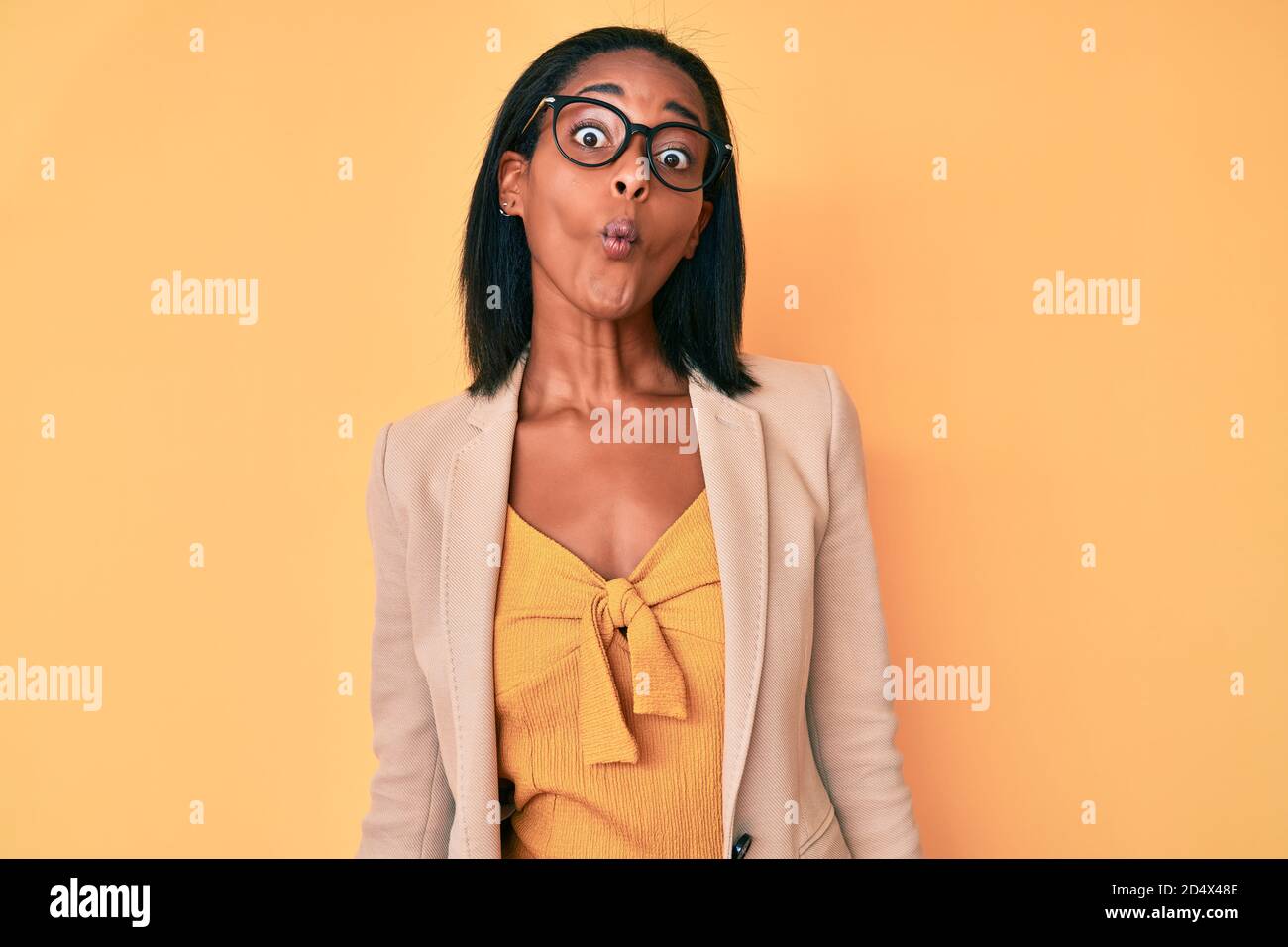 Young african american woman wearing business clothes making fish face ...