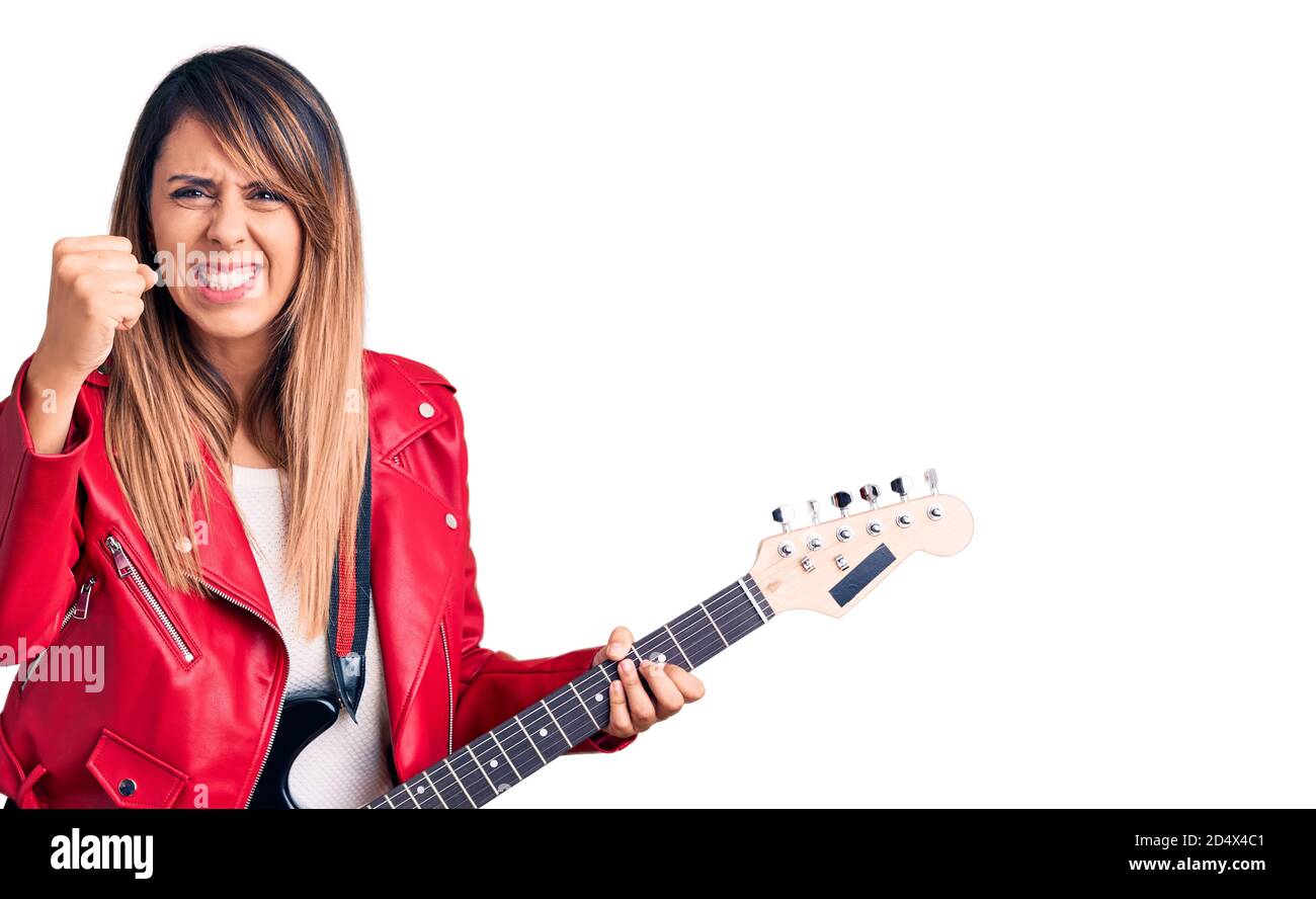 Young beautiful woman playing electric guitar annoyed and frustrated ...