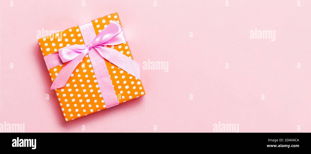 wrapped Christmas or other holiday handmade present in paper with pink ...