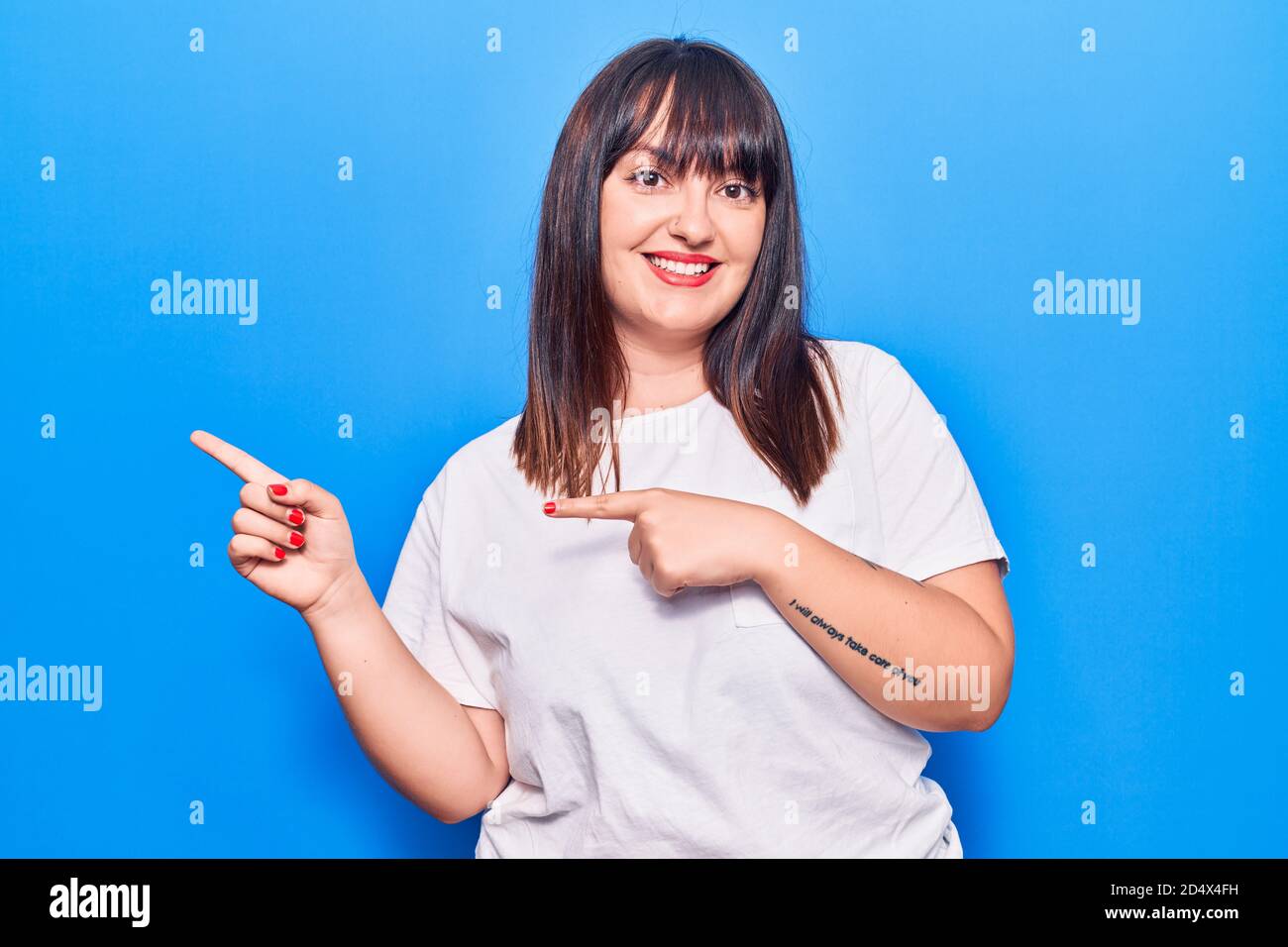 Young plus size woman wearing casual clothes smiling and looking at the ...