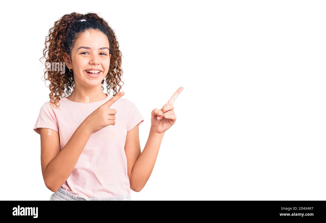 Beautiful kid girl with curly hair wearing casual clothes smiling and ...