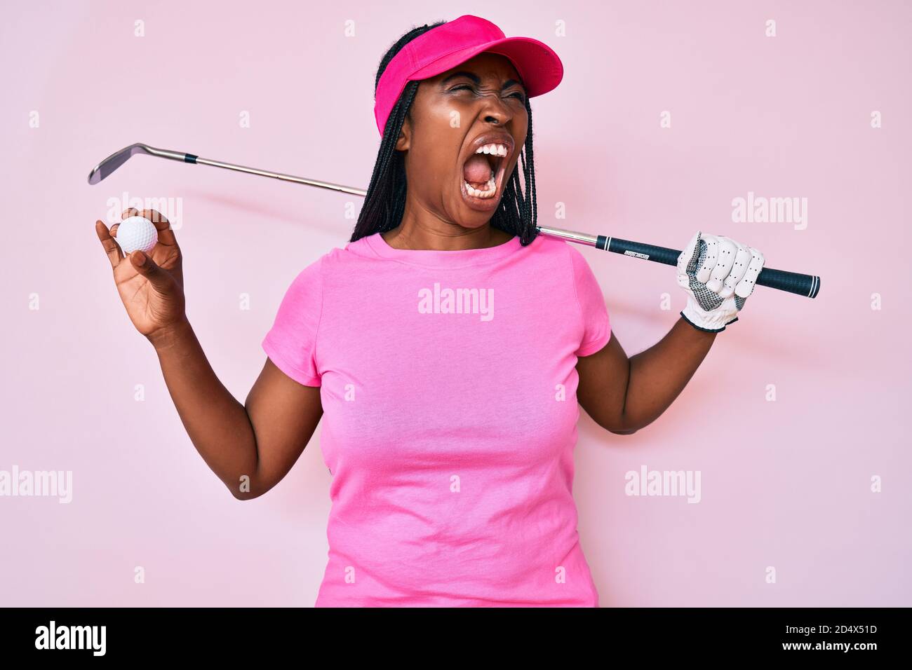 African american golfer woman with braids holding golf ball angry and ...