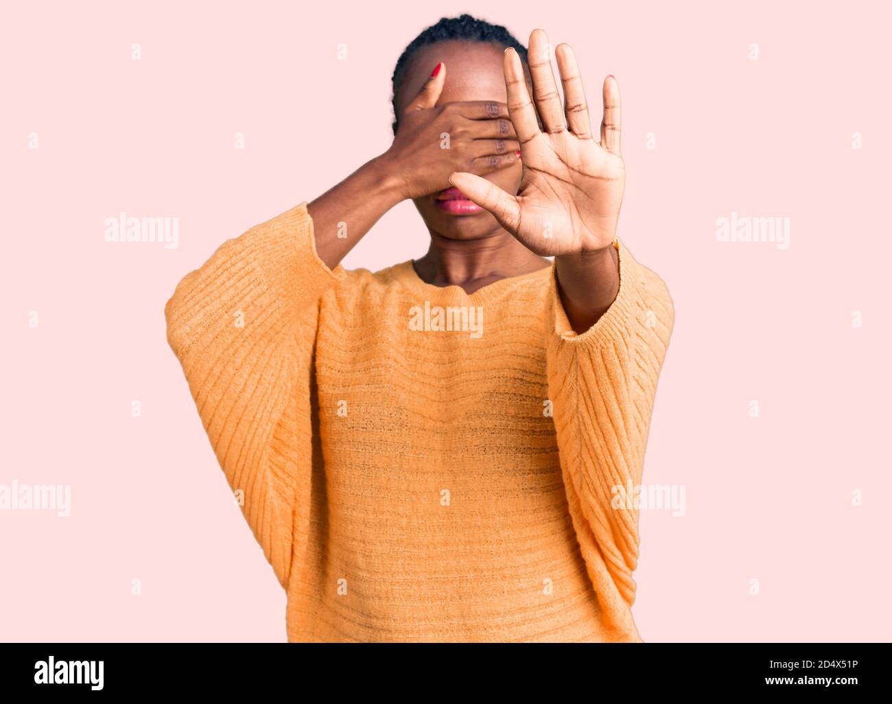 Young african american woman wearing casual clothes covering eyes with ...