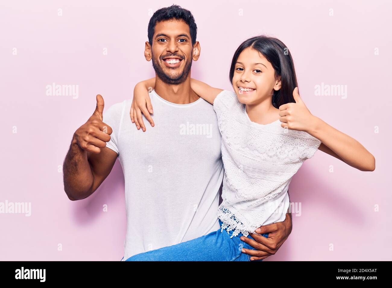 Latin father and daughter wearing casual clothes smiling happy and ...