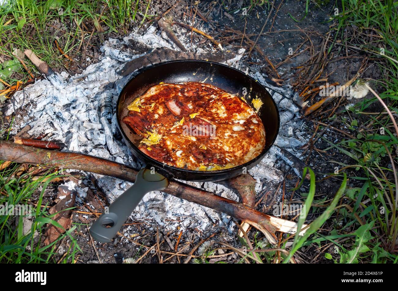 Cooking Dinner on campfire in cast iron pan. bbq photo Stock Photo - Alamy