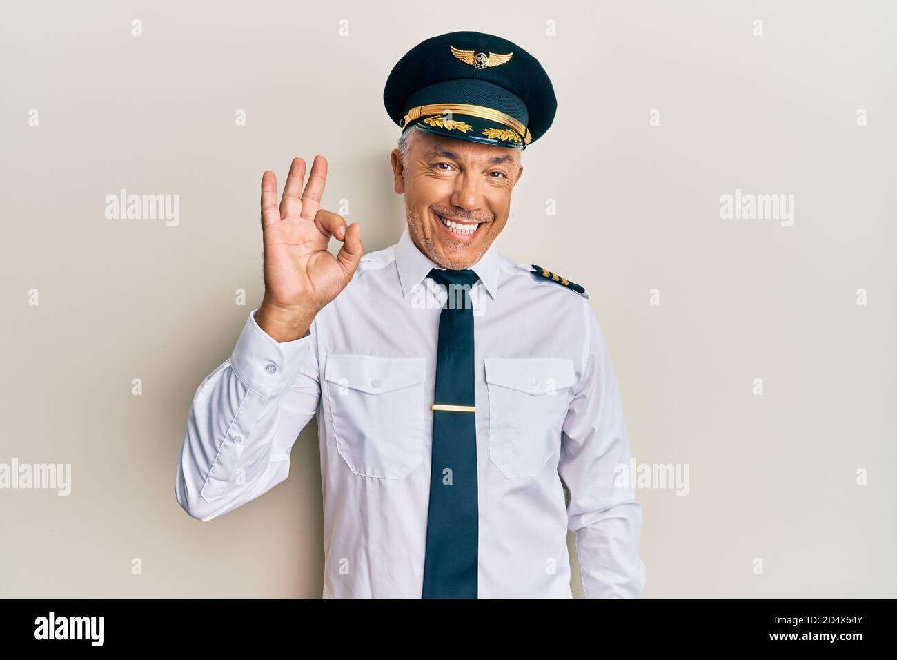 Handsome middle age mature man wearing airplane pilot uniform smiling ...