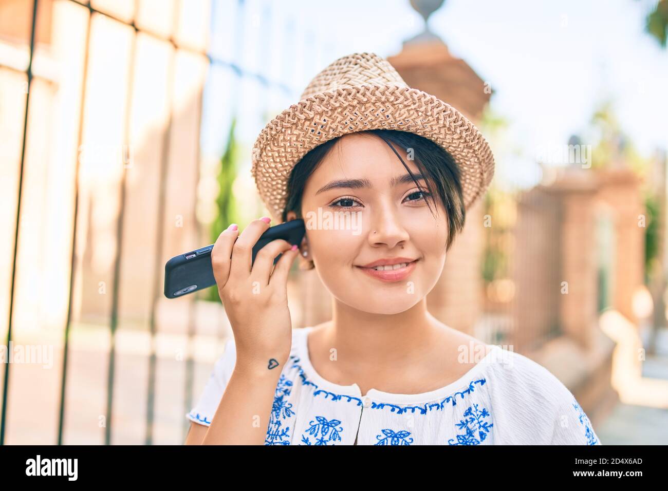 Young latin tourist girl on vacation smiling happy listening audio ...