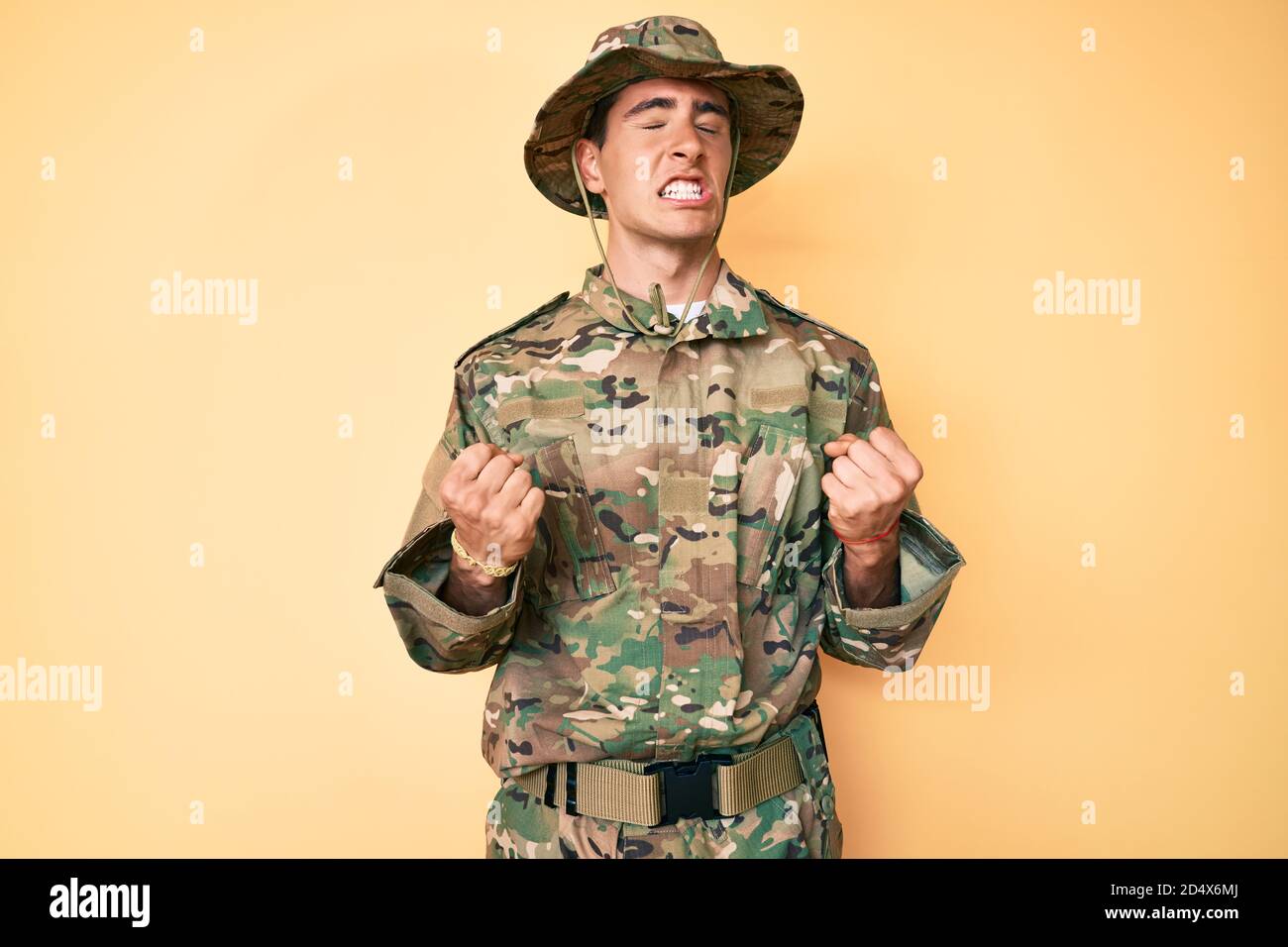 Young handsome man wearing camouflage army uniform excited for success ...