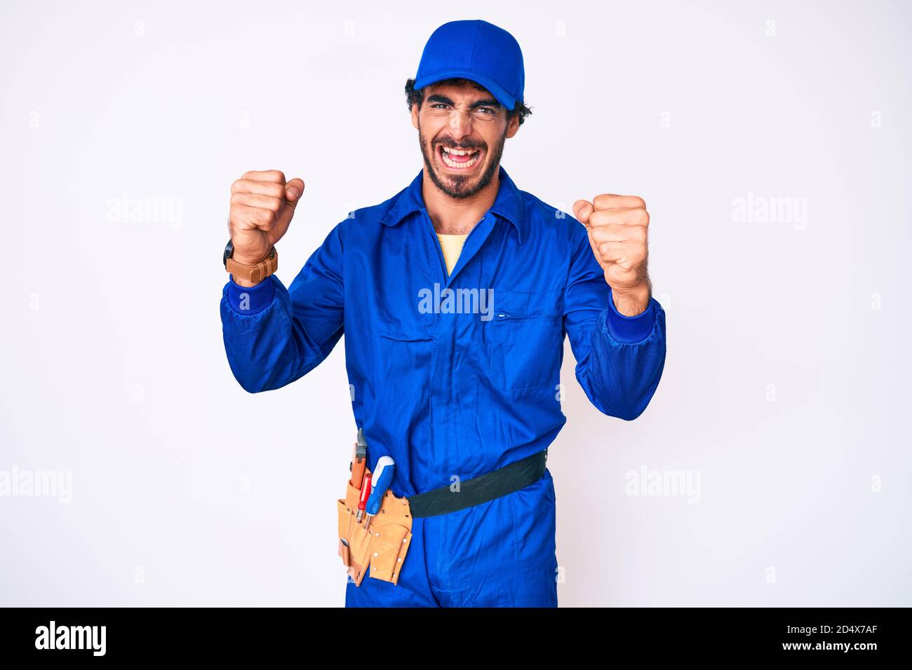 Handsome young man with curly hair and bear weaing handyman uniform ...