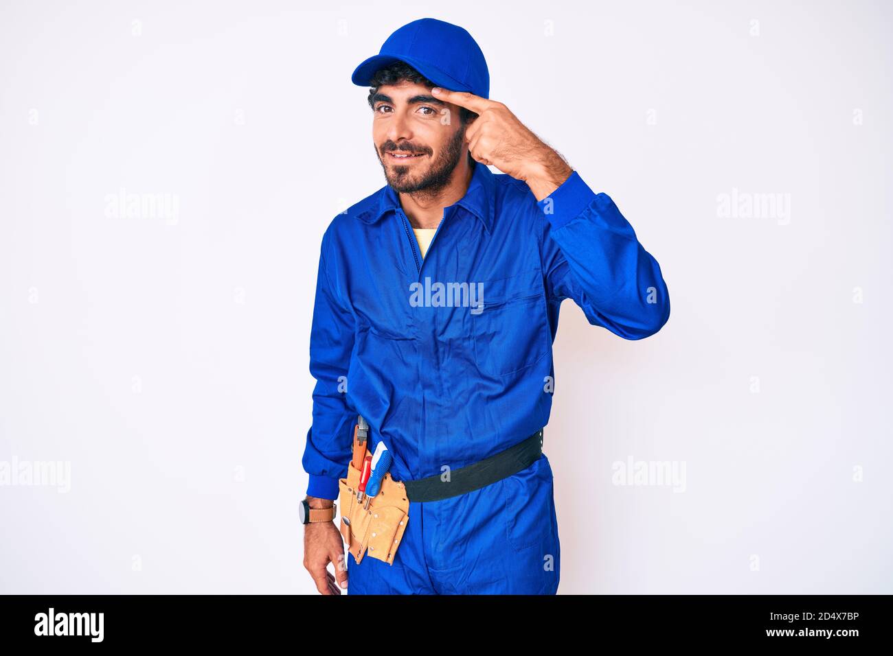Handsome young man with curly hair and bear weaing handyman uniform ...