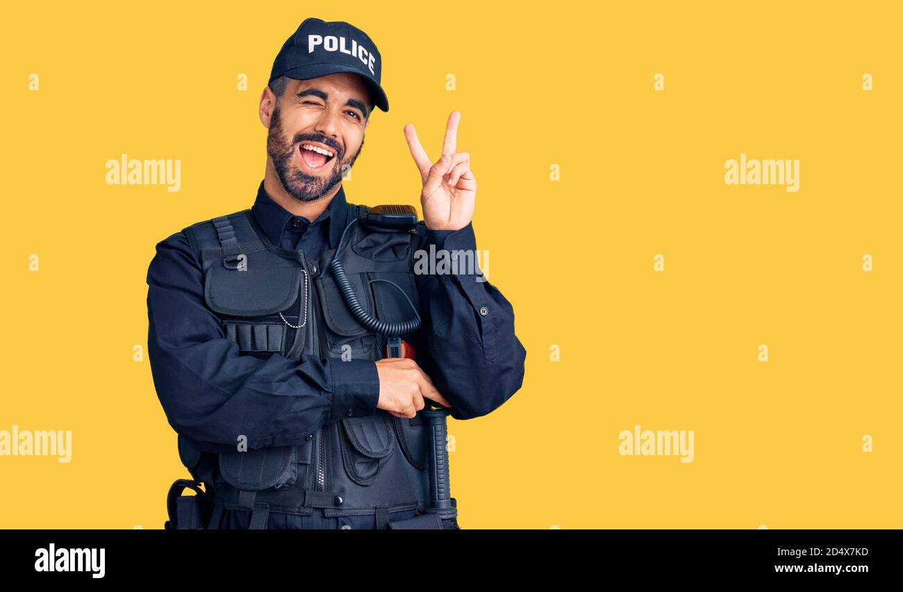 Young hispanic man wearing police uniform smiling with happy face ...