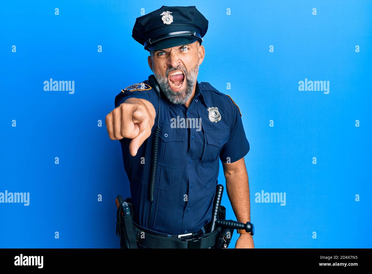 Middle age handsome man wearing police uniform pointing displeased and ...