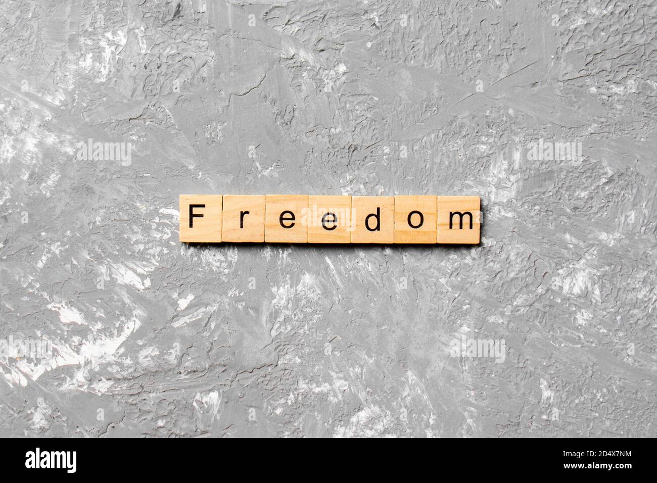 Freedom word written on wood block. Freedom text on cement table for ...